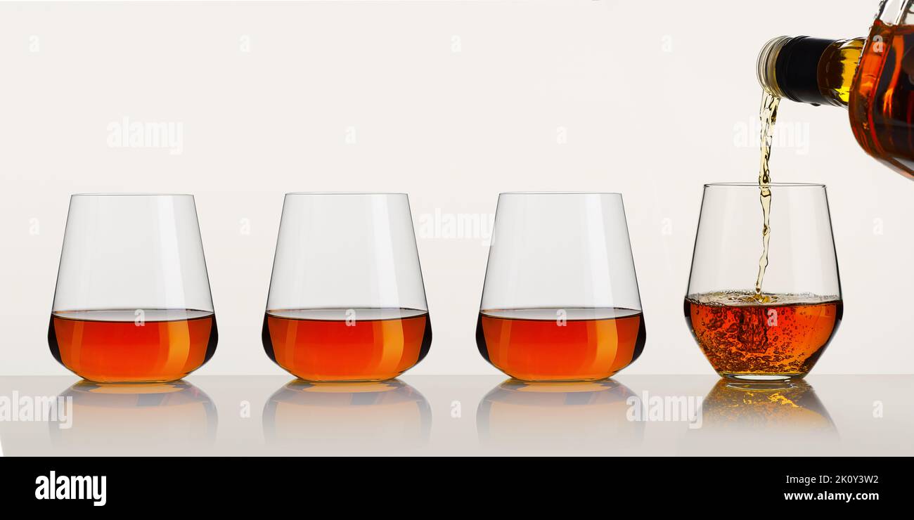 Whiskey oder Brandy, der aus einer Flasche auf weißem Hintergrund in ...