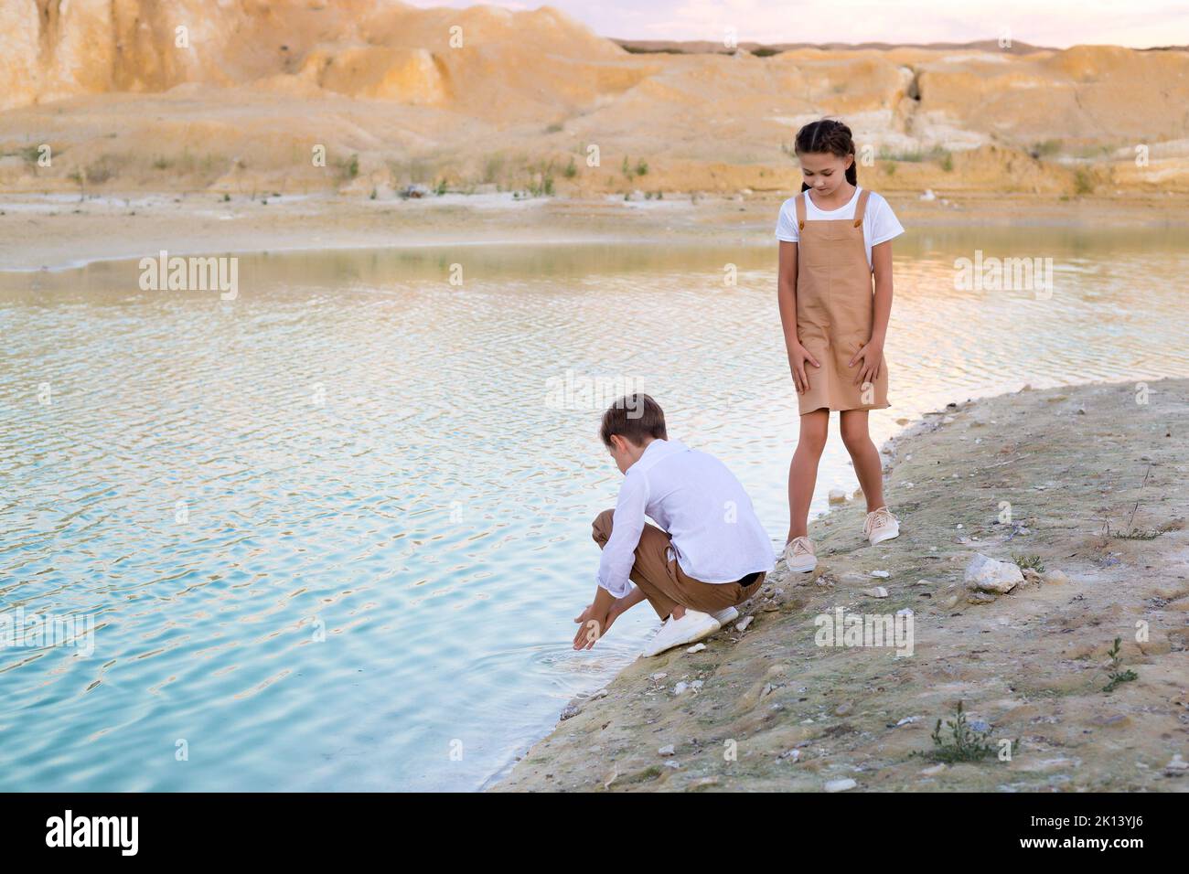 Kinder waschen sich im See die Hände, Bruder und Schwester ruhen sich ...