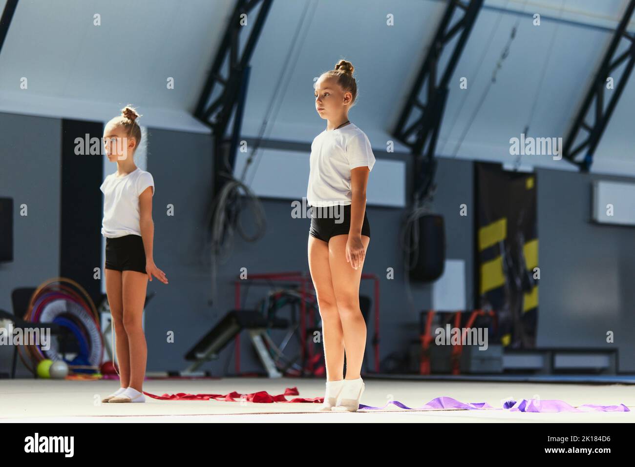 Zwei kleine Mädchen, weibliche rhythmische Turnerin Training mit bunten ...