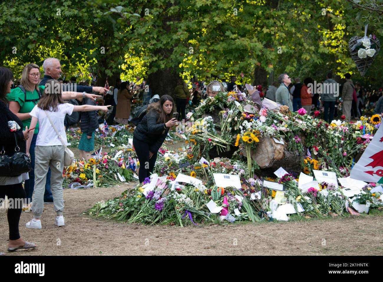 Familie zeigt auf die Blumen, die sie nach dem Tod der Queen in Green ...