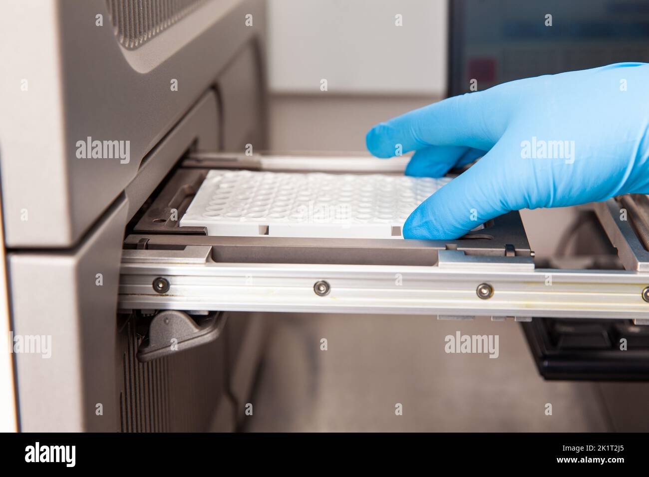 Wissenschaftler beladen Proben in einen RT-PCR-Thermocycler im Labor ...