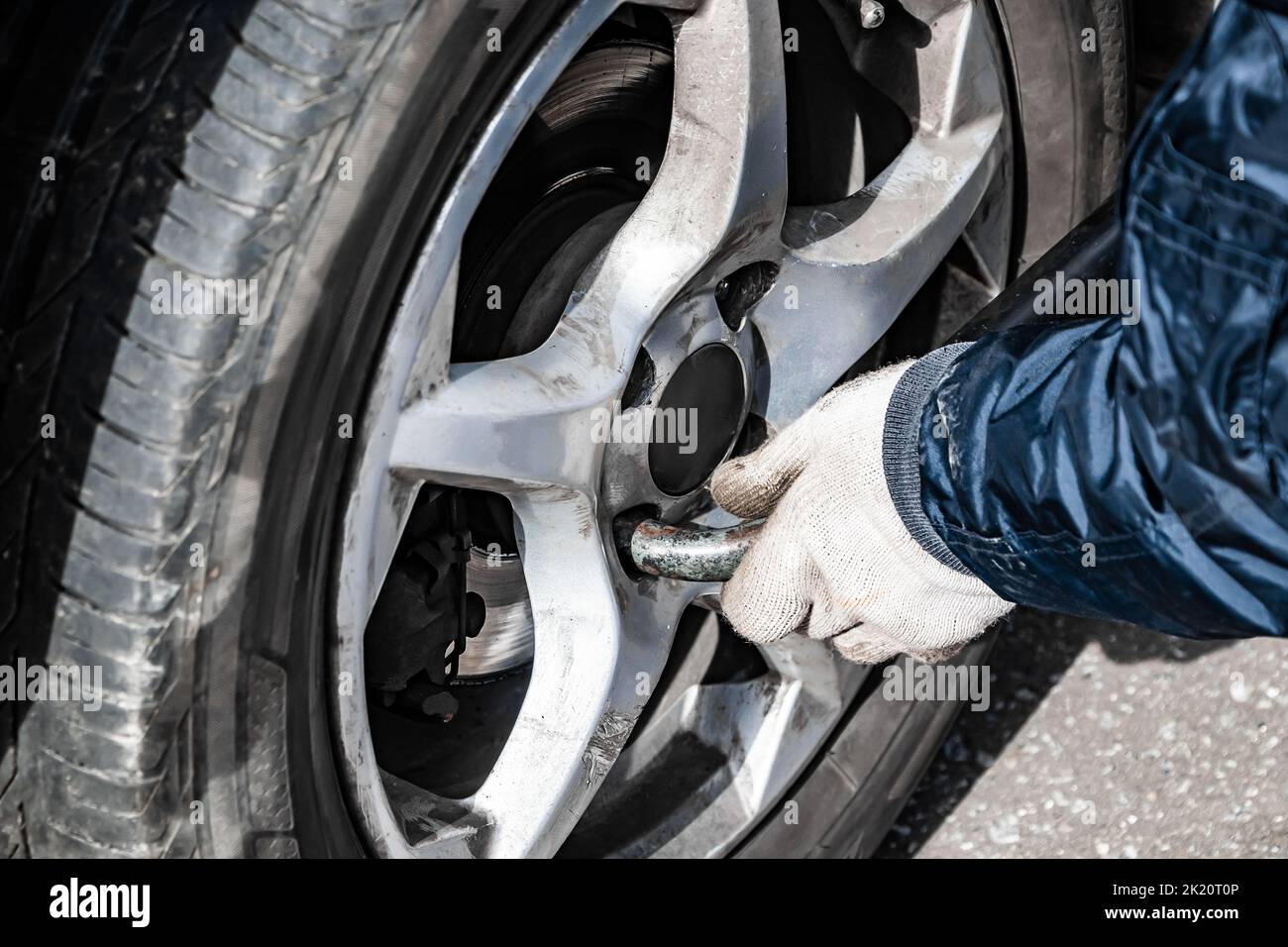 Der Automechaniker wechselt das Rad des alten Autos. Der Mann wechselt ...