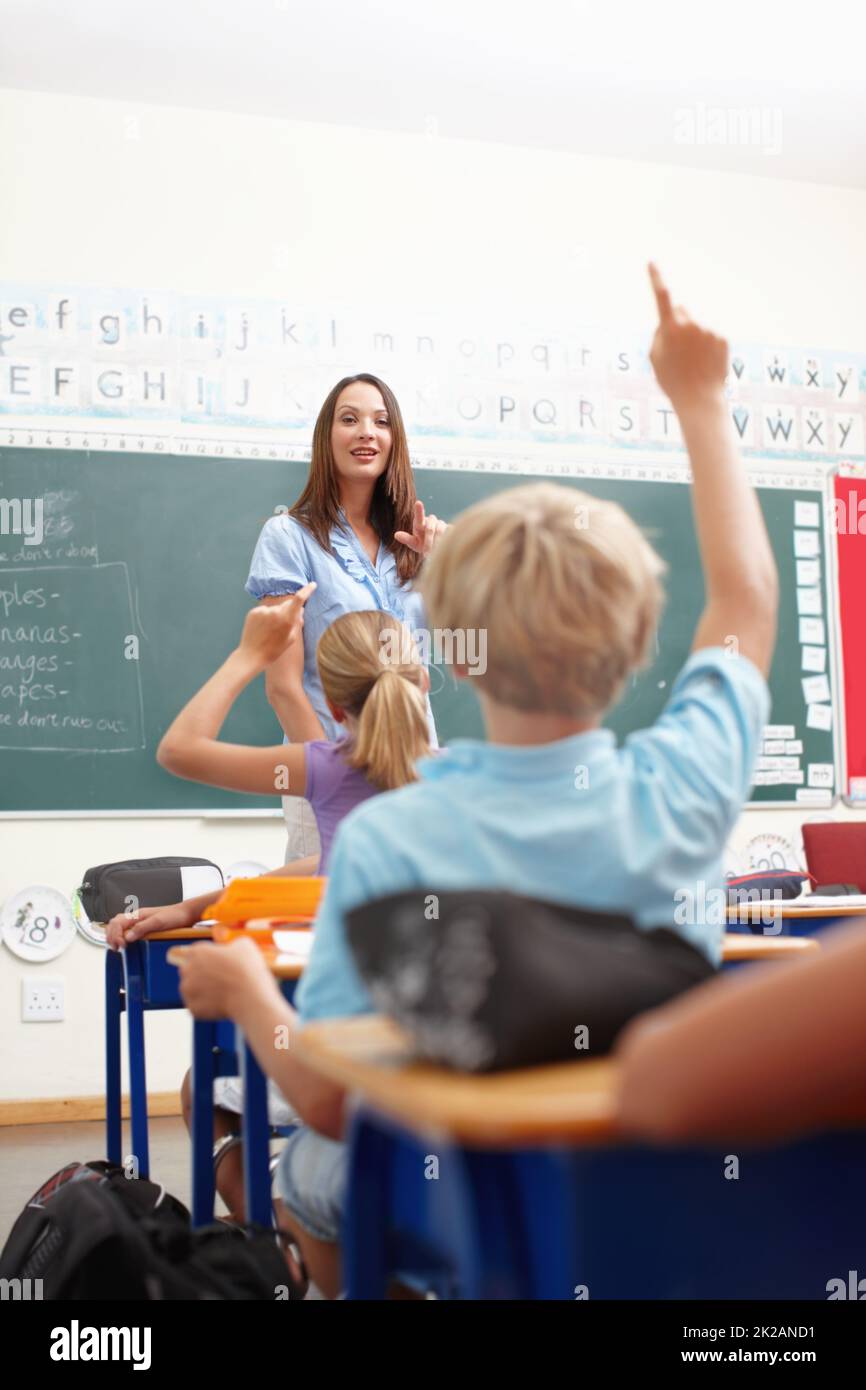 Ich habe eine Frage.... Eine hübsche junge Lehrerin, die an der Tafel der Klasse steht und ...