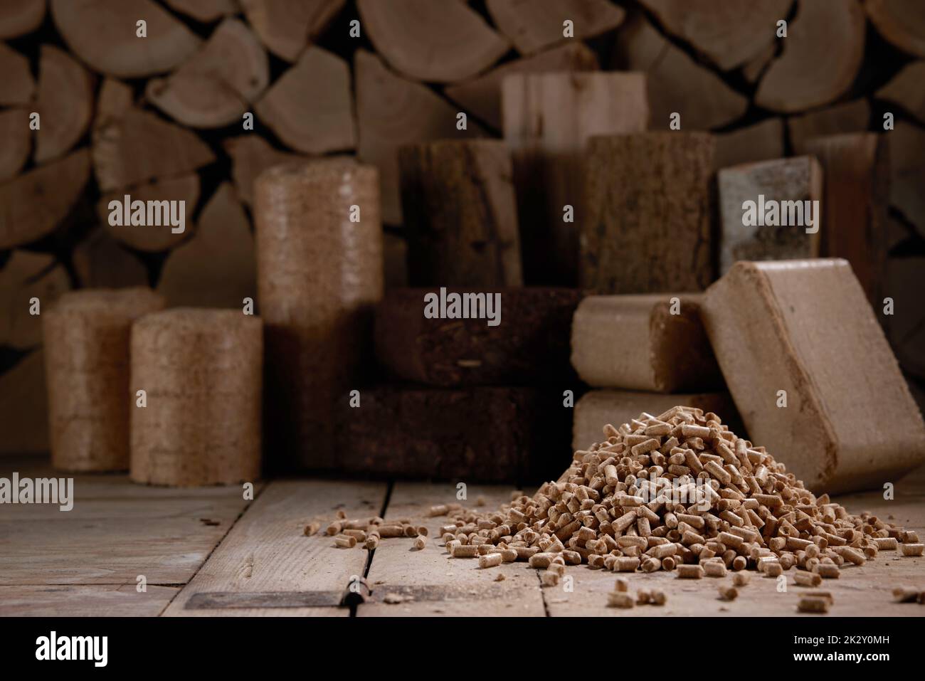 In der Nähe von Biokraftstoffbriketts und Brennholz verstreute Pellets ...