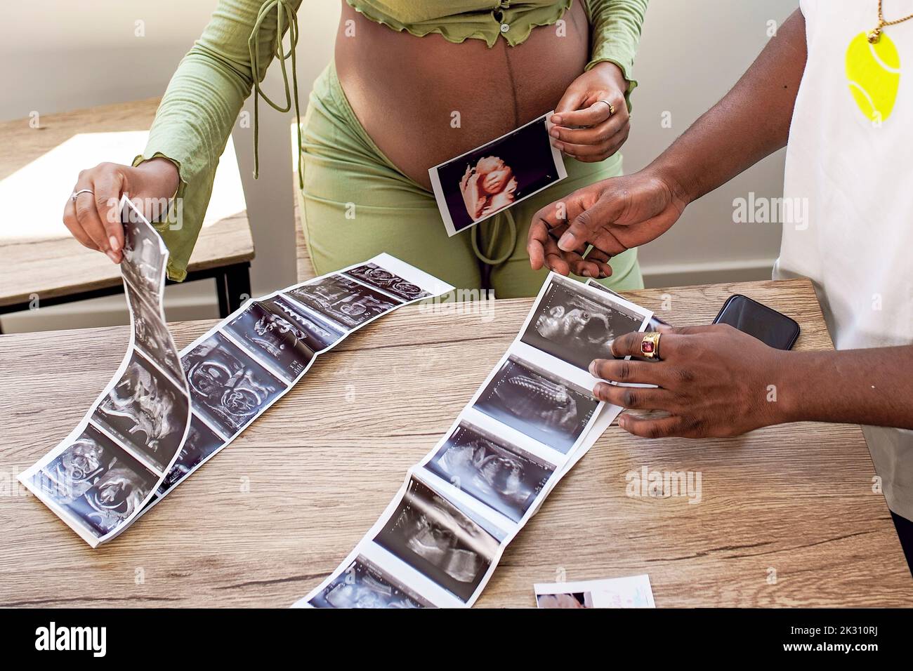 Schwangere Frau arrangiert Ultraschallbild des Babys mit Mann zu Hause ...