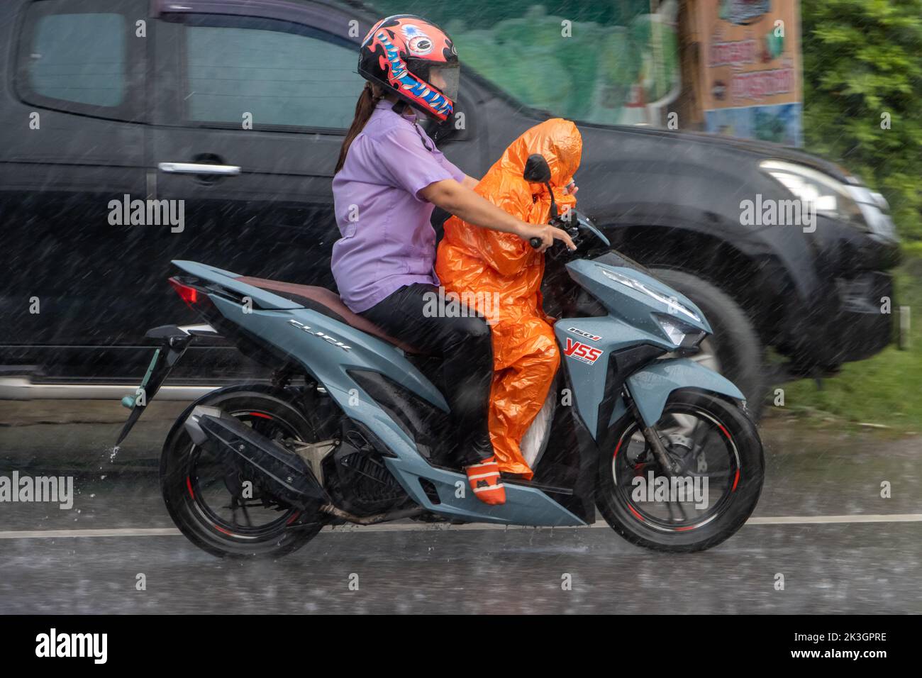 SAMUT PRAKAN, THAILAND, SEP 21 2022, Eine Frau fährt bei starkem Regen ...