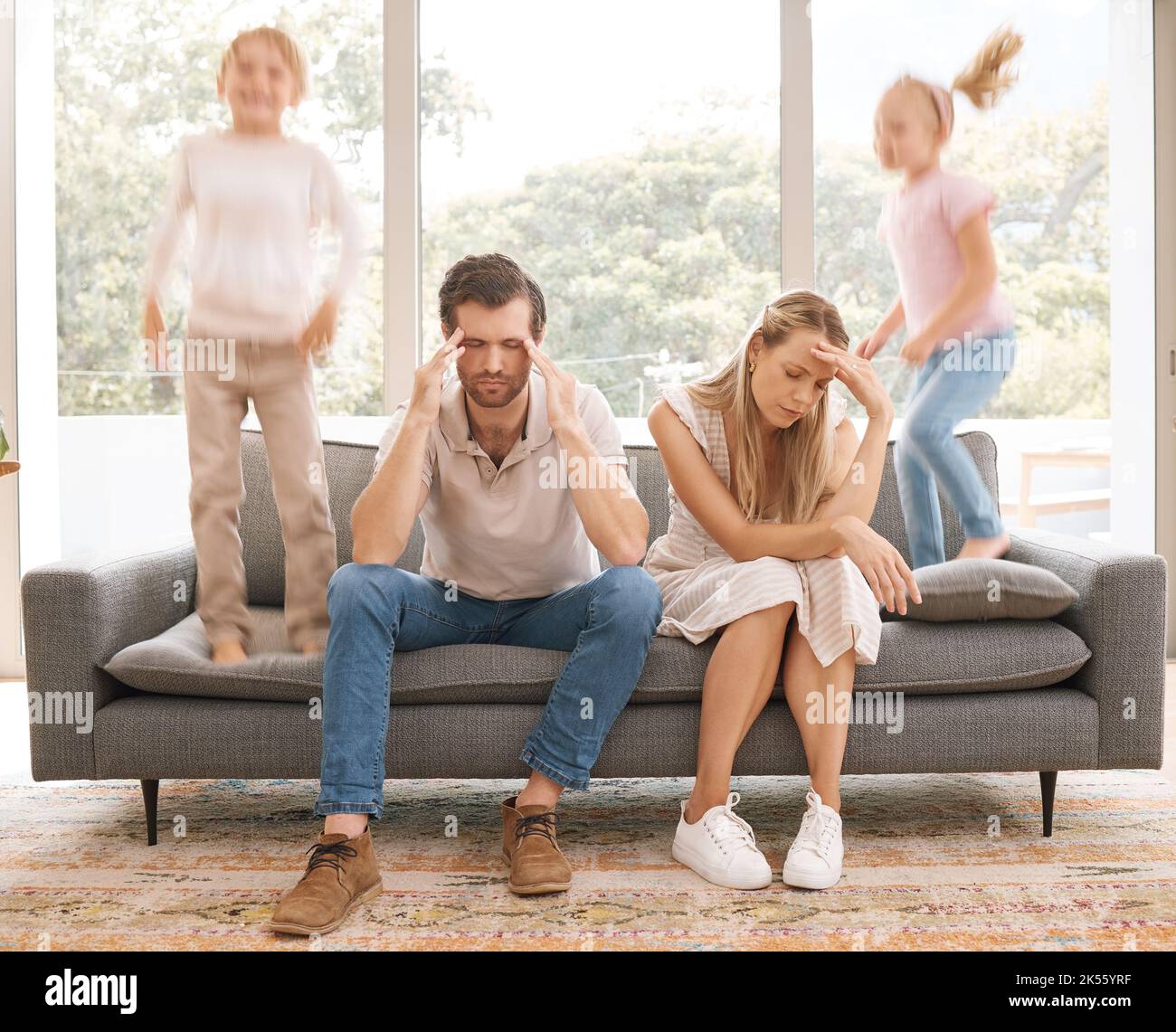 Stress Eltern, Kinder und Sprung auf dem Sofa im Wohnzimmer Kinderproblem für müde, traurig und ...