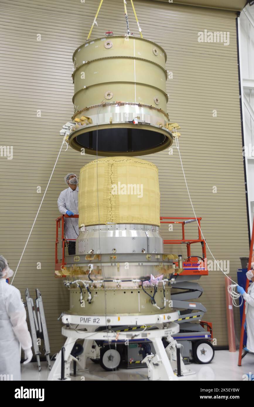 Techniker verwenden einen Kran, um den Nutzlastadapterbehälter für den ...