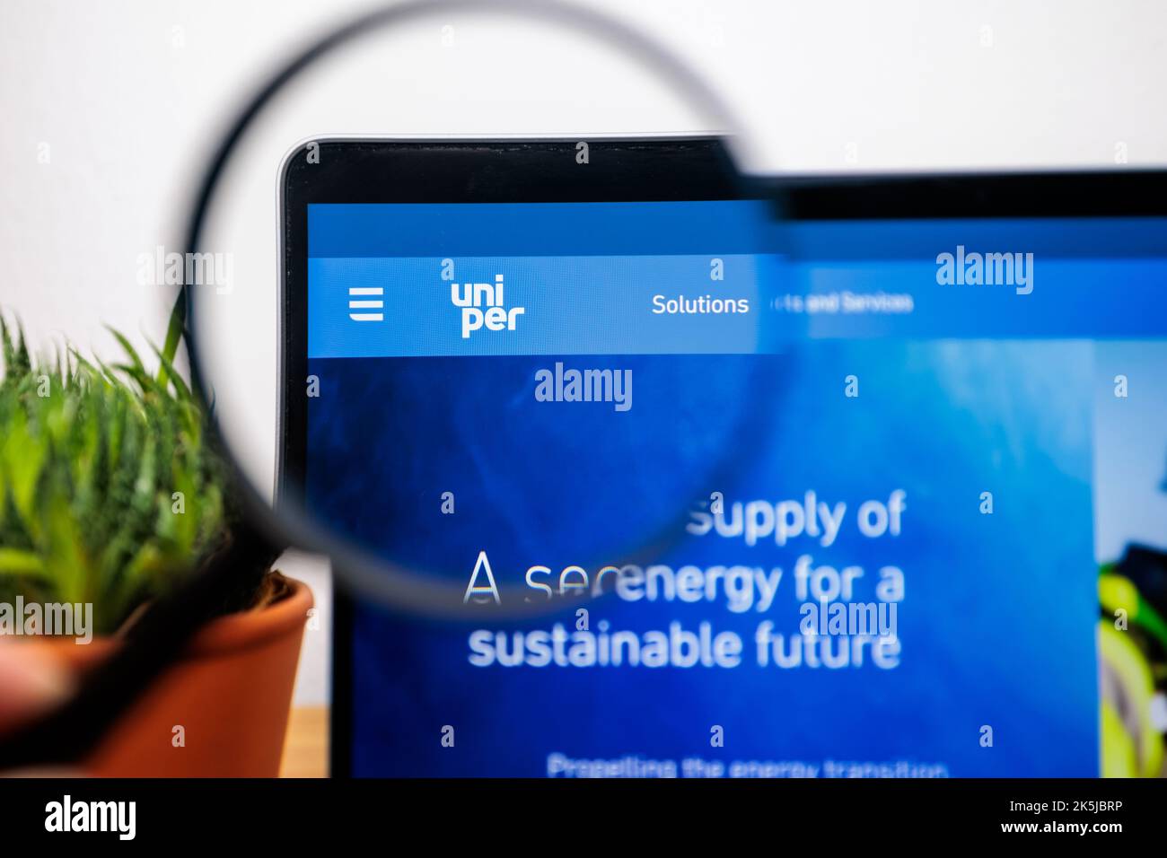Das Logo von Uniper auf einem Laptop-Desktop unter einer Lupe ...