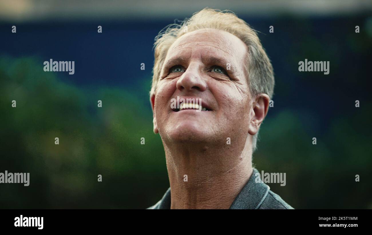 Dankbarer reifer Mann, der mit HOFFNUNG am Himmel lächelt. Eine treue ...