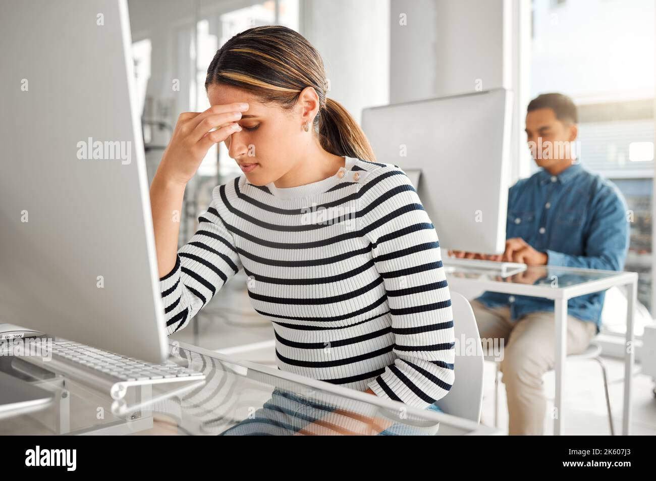 Junge gestresste Geschäftsfrau mit gemischter Rasse, die bei der Arbeit ...