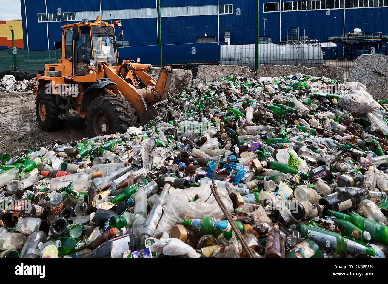 Der Eimer-Lader bricht Glasflaschen, indem er sie aus dem Eimer abgibt ...