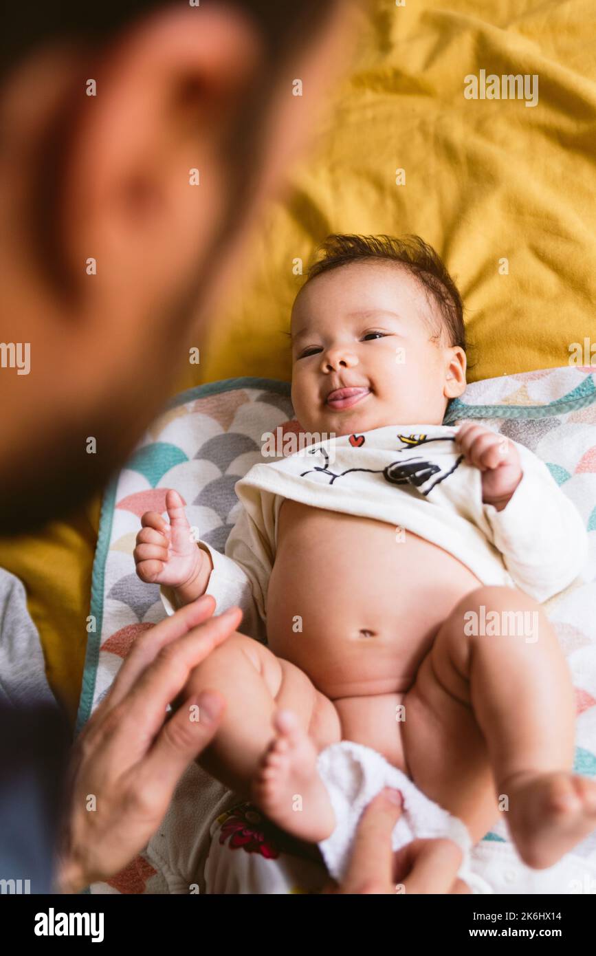 Vertikale Aufnahme des Babys während des Windelwechsels durch den ...