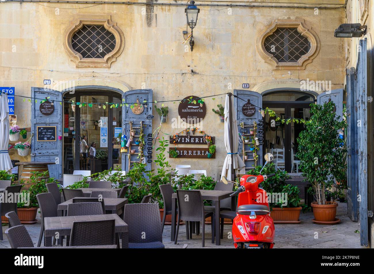 Sitzplätze im Freien und rotes Moped vor dem Restaurant Salumeria Di ...