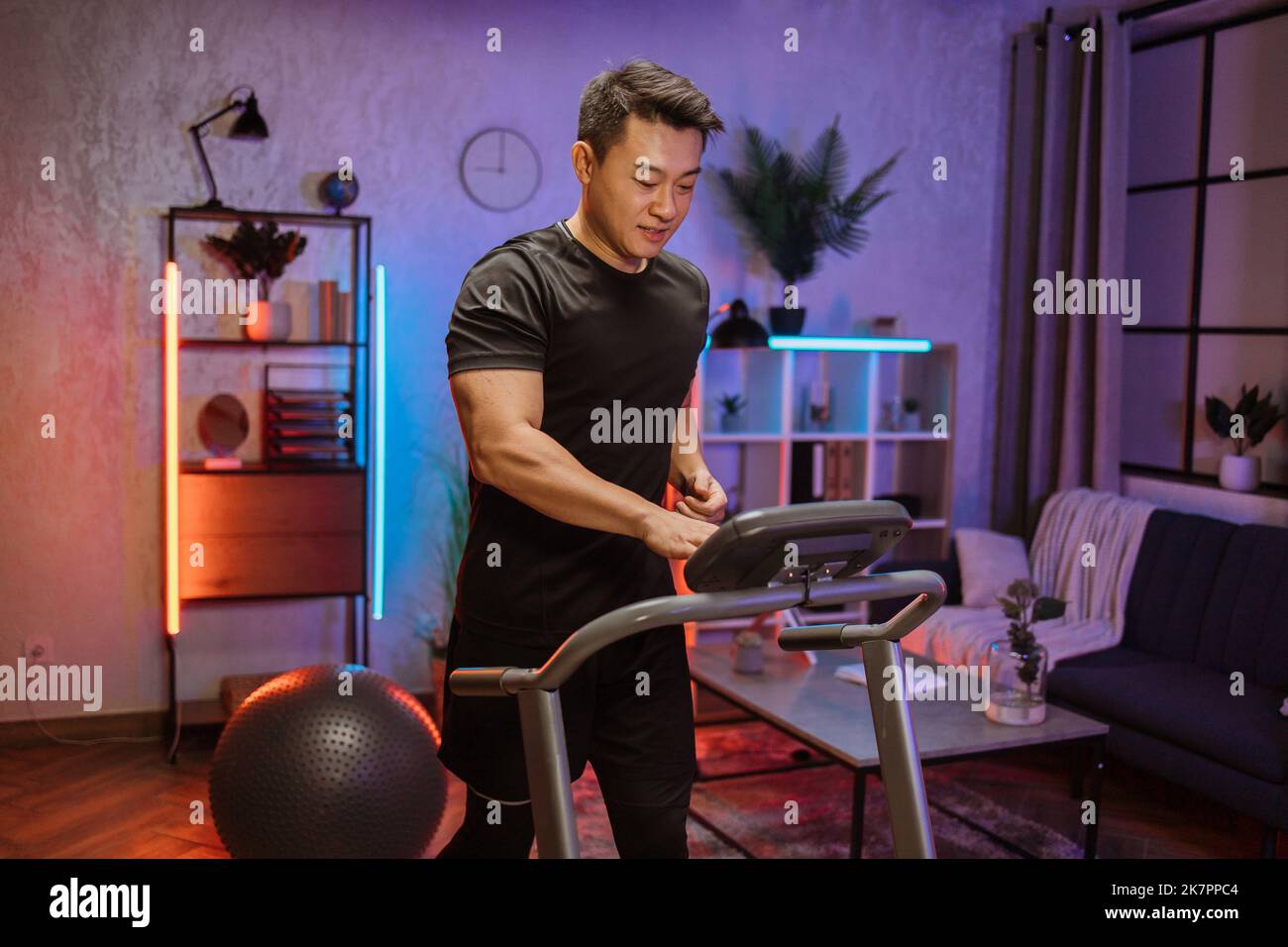 Porträt eines aktiven asiatischen Mannes in Sportbekleidung, der nachts ... Porträt eines aktiven asiatischen Mannes in Sportbekleidung, der nachts ...