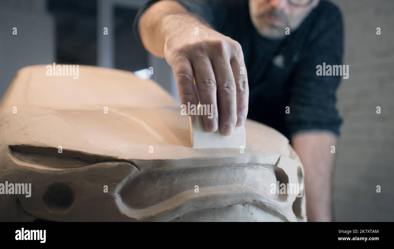 Erfahrene Autodesigner arbeiten an der Skulptur eines Prototypen ...