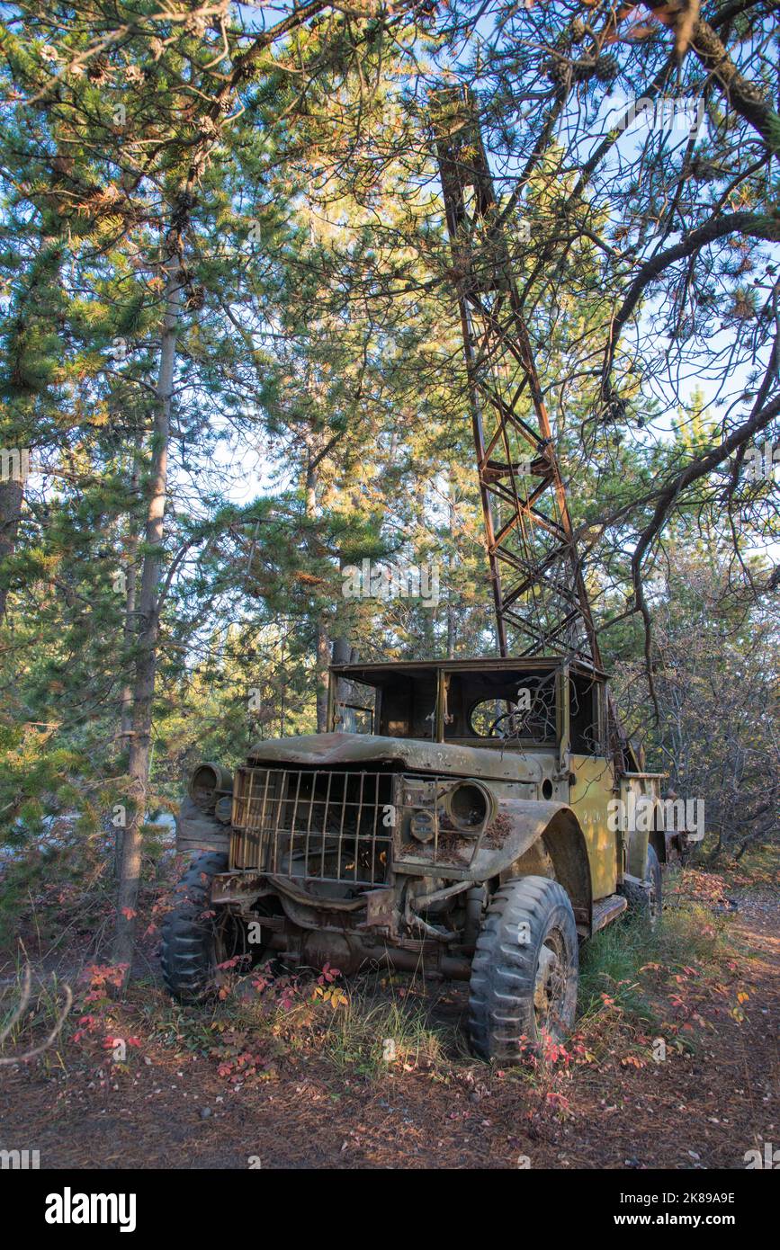 Ein alter rostiger verlassener LKW sitzt im Wald vor einem Kran ...