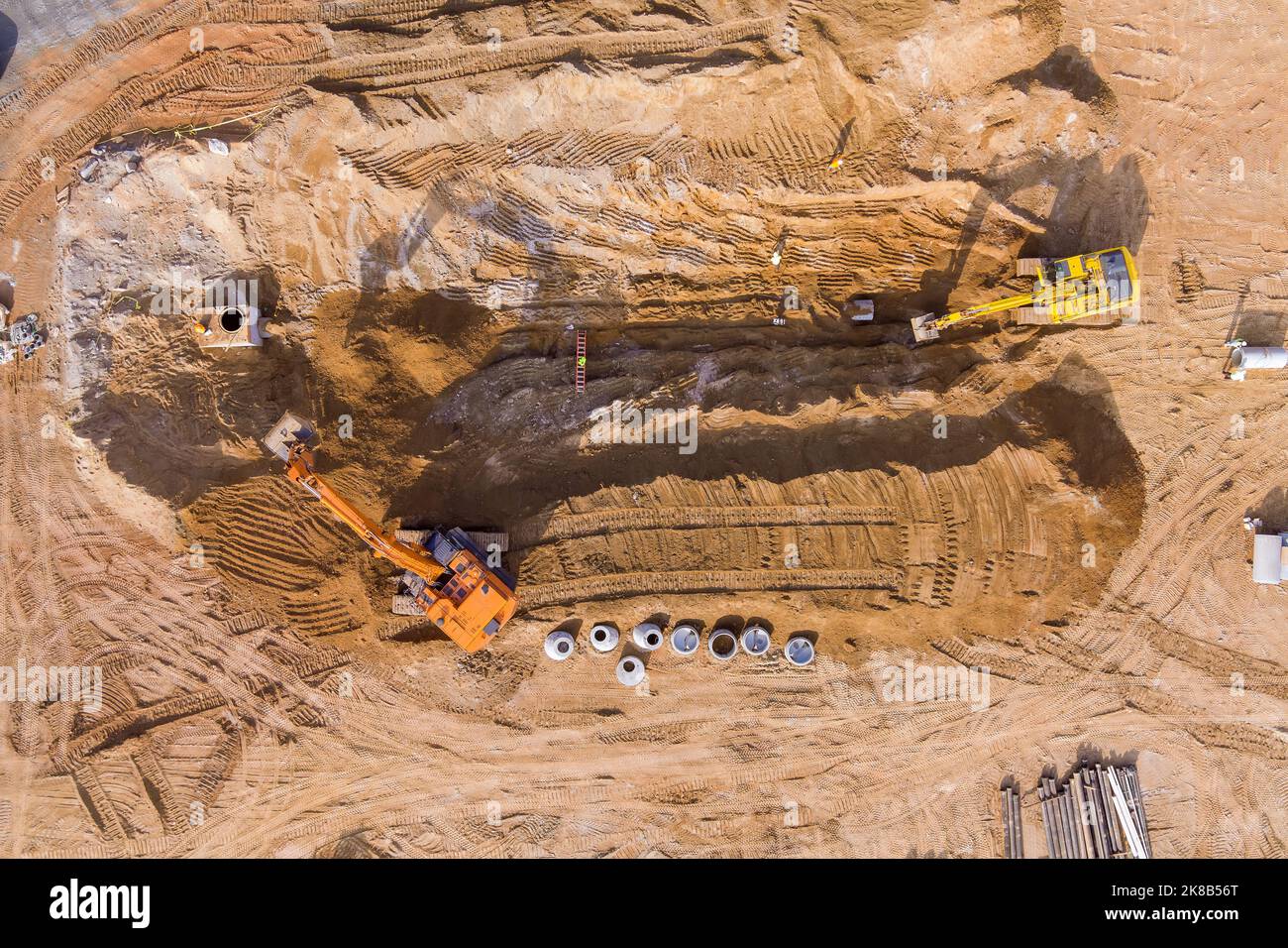 Auf der Baustelle gräbt ein Bagger Graben für die Verlegung von ...