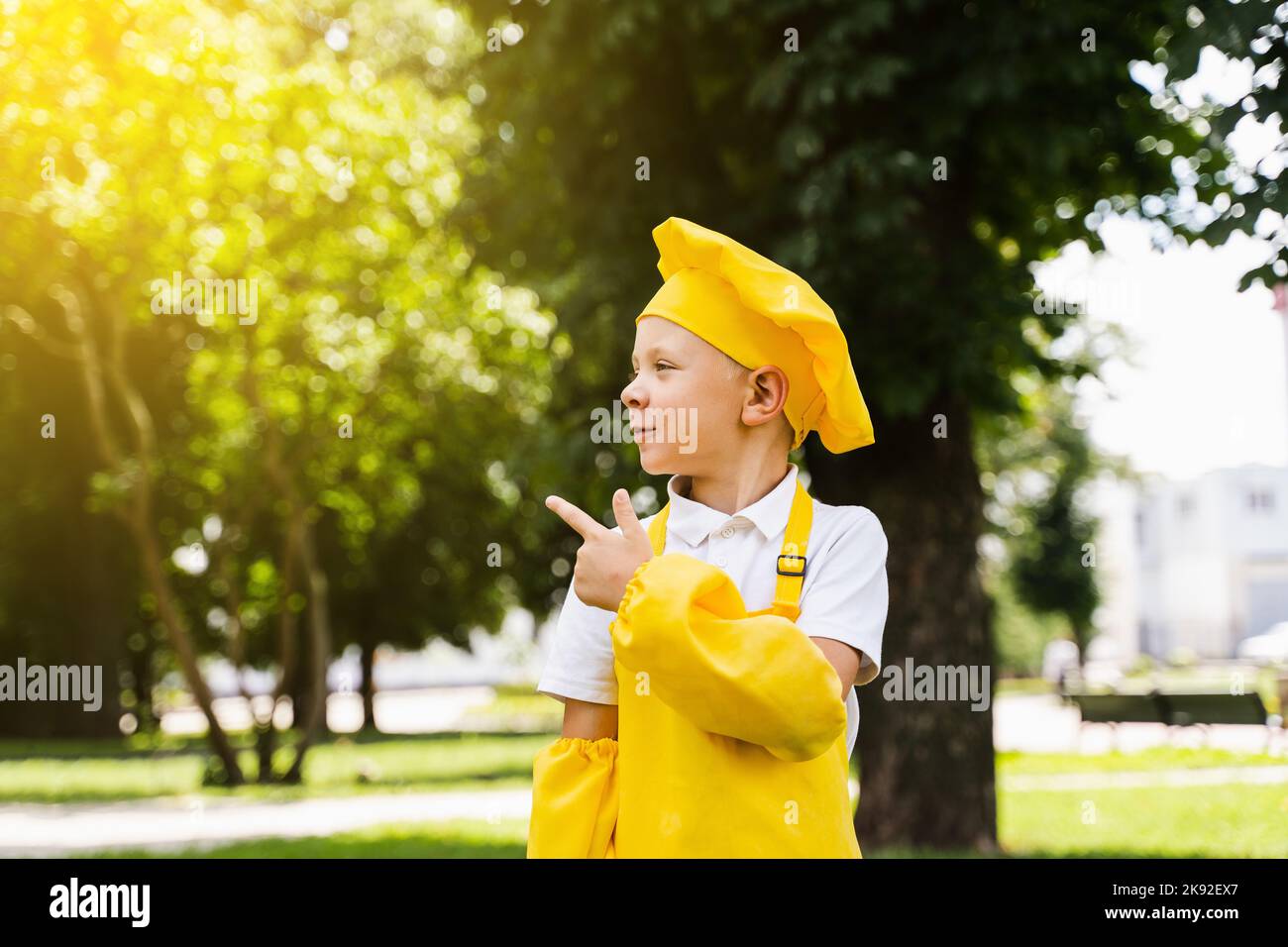 Zeigt richtig. Schöner Koch Kind in gelben Köchhut und Schürze gelbe ...