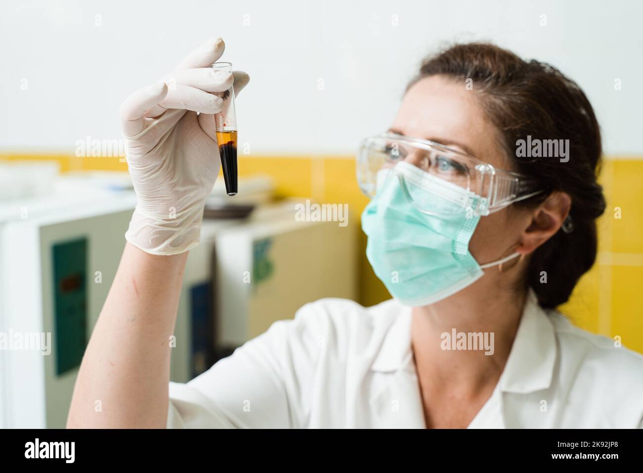 Analyse von Blutplasma. Der Laborant hält ein Reagenzglas mit Blut aus ...