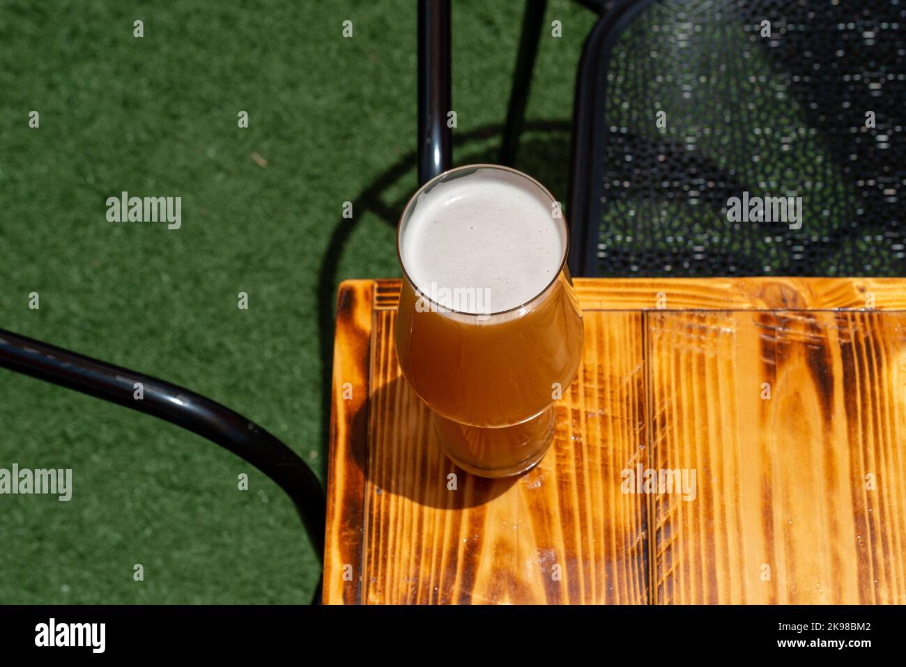 Ein hohes Glas kaltes Craft-Bier mit einem dicken Kopf aus weißem ...