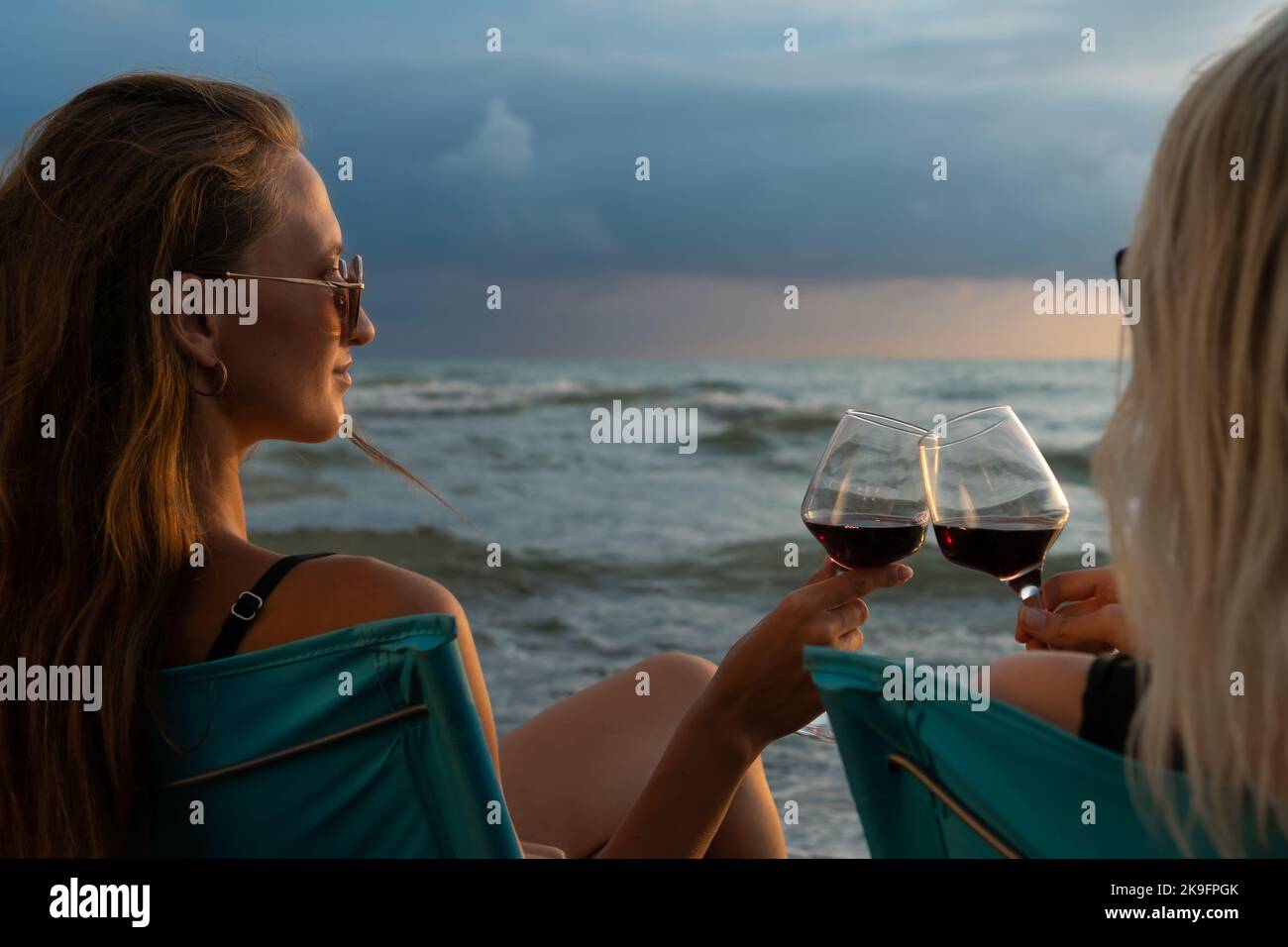 Zwei freundinnen sitzen am strand -Fotos und -Bildmaterial in hoher ...