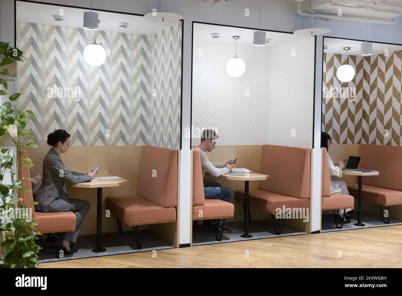 Drei beschäftigte Mitarbeiter, die im Coworking Space mit Trennwänden sitzen Stockfotografie - Alamy