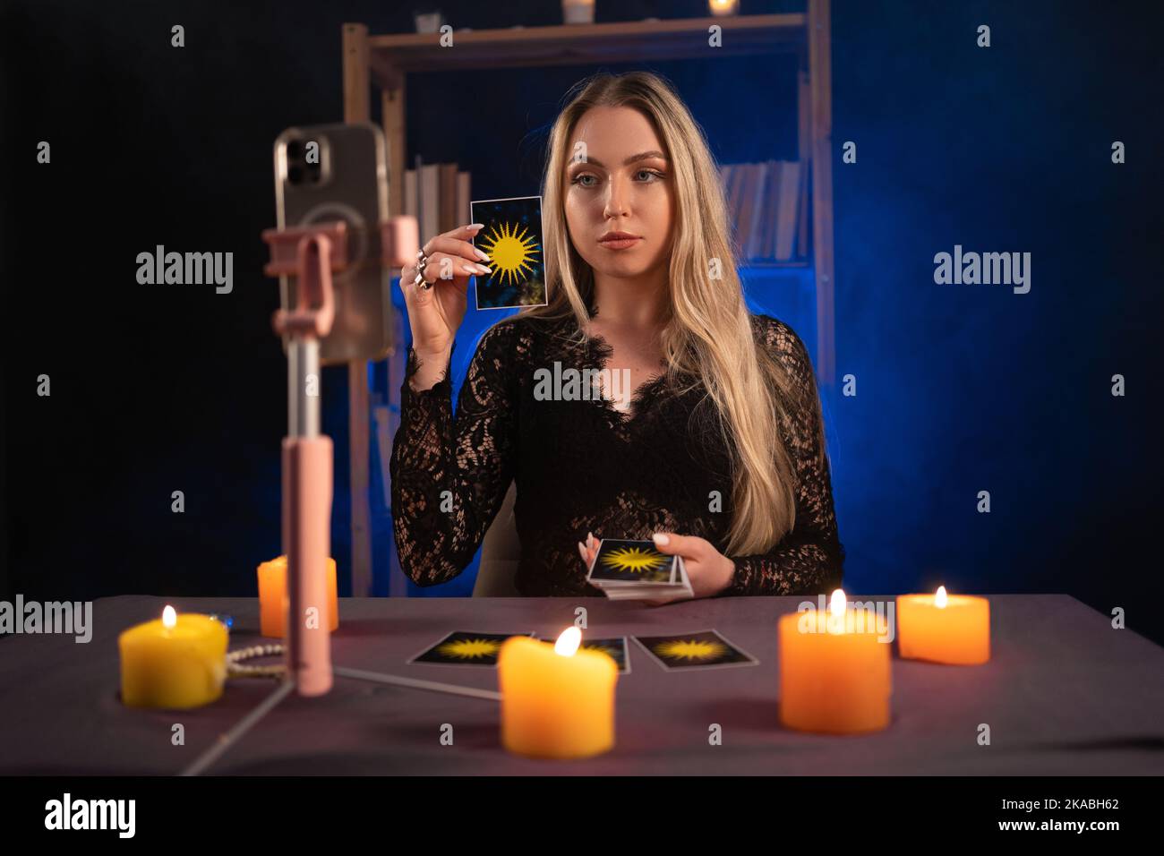 Junge Wahrsagerin öffnen Tarot-Karte im schwarzen Raum, um die Zukunft ...