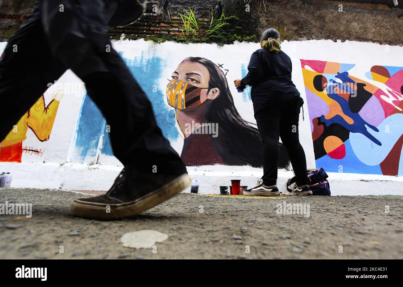 Ein indonesischer Künstler aus der Region zeichnet ein Coronavirus-Awareness-Graffiti an den ...