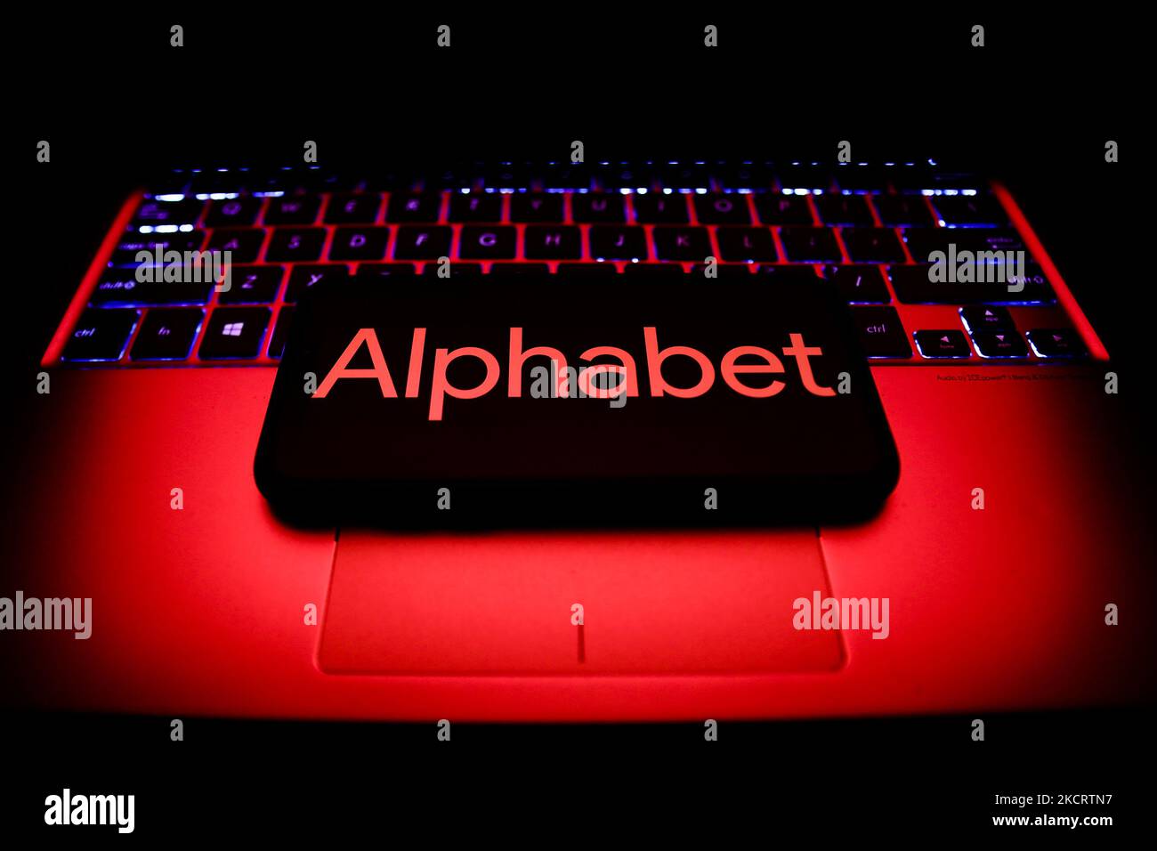 Das Alphabet-Logo, das auf einem Telefonbildschirm und einer Laptop ...