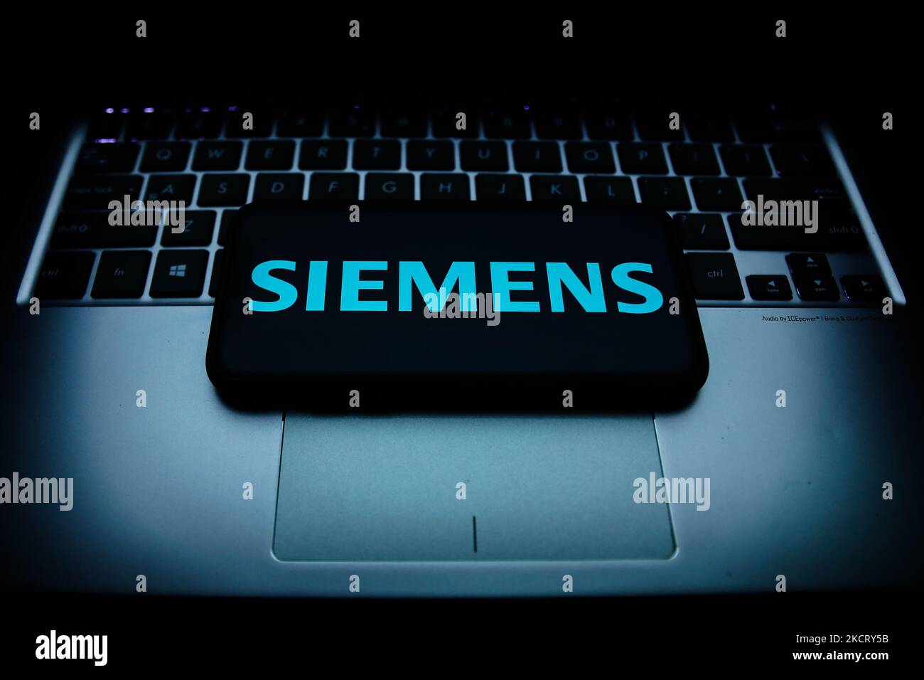 Das Siemens-Logo, das auf einem Telefonbildschirm und einer Laptop ...