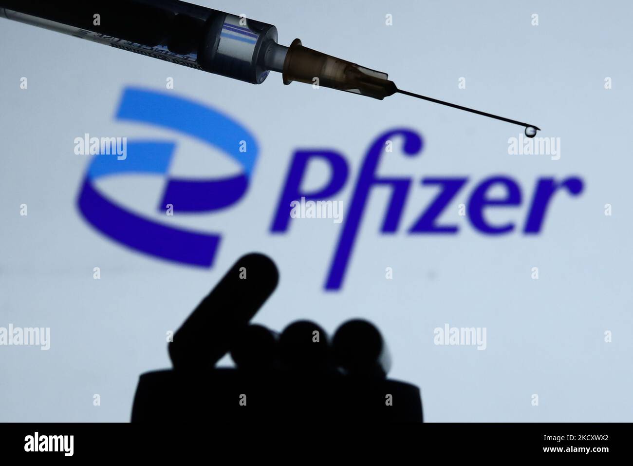 Medizinische Spritze und Medikamentententabletten sind mit dem Pfizer ...