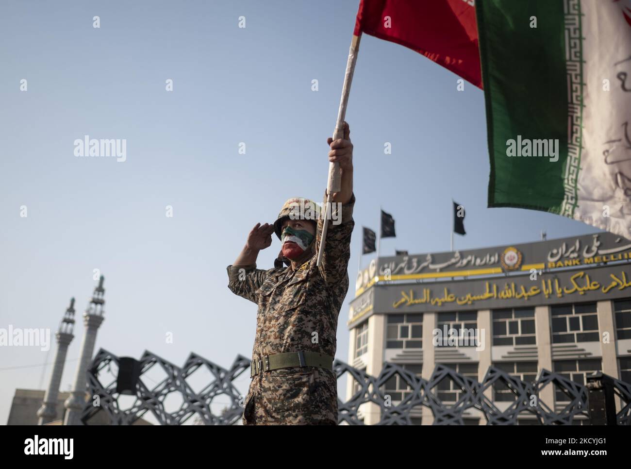 Ein Iraner, der sein Gesicht als iranische Flagge mit einer Uniform des ...