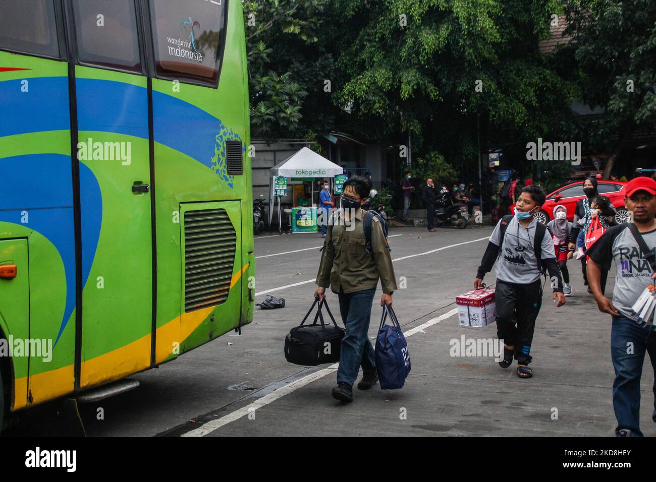 Eine Familie trägt ihre Habseligkeiten, als sie den Bus finden, der sie ...