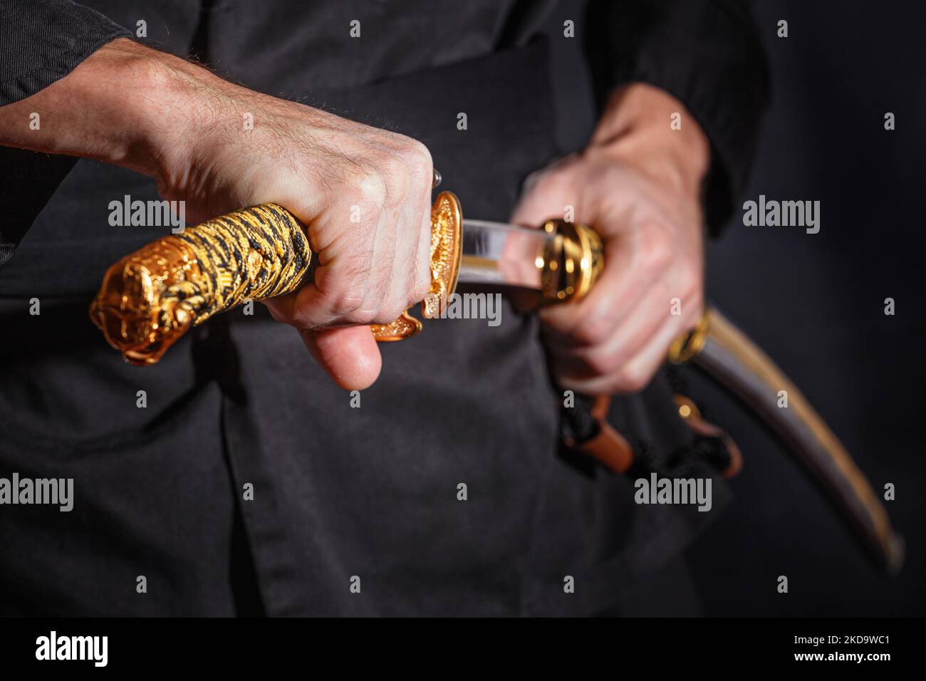 Der Samurai mit einem japanischen Katana-Schwert. Foto eines Kriegers in schwarzer Kleidung in ...