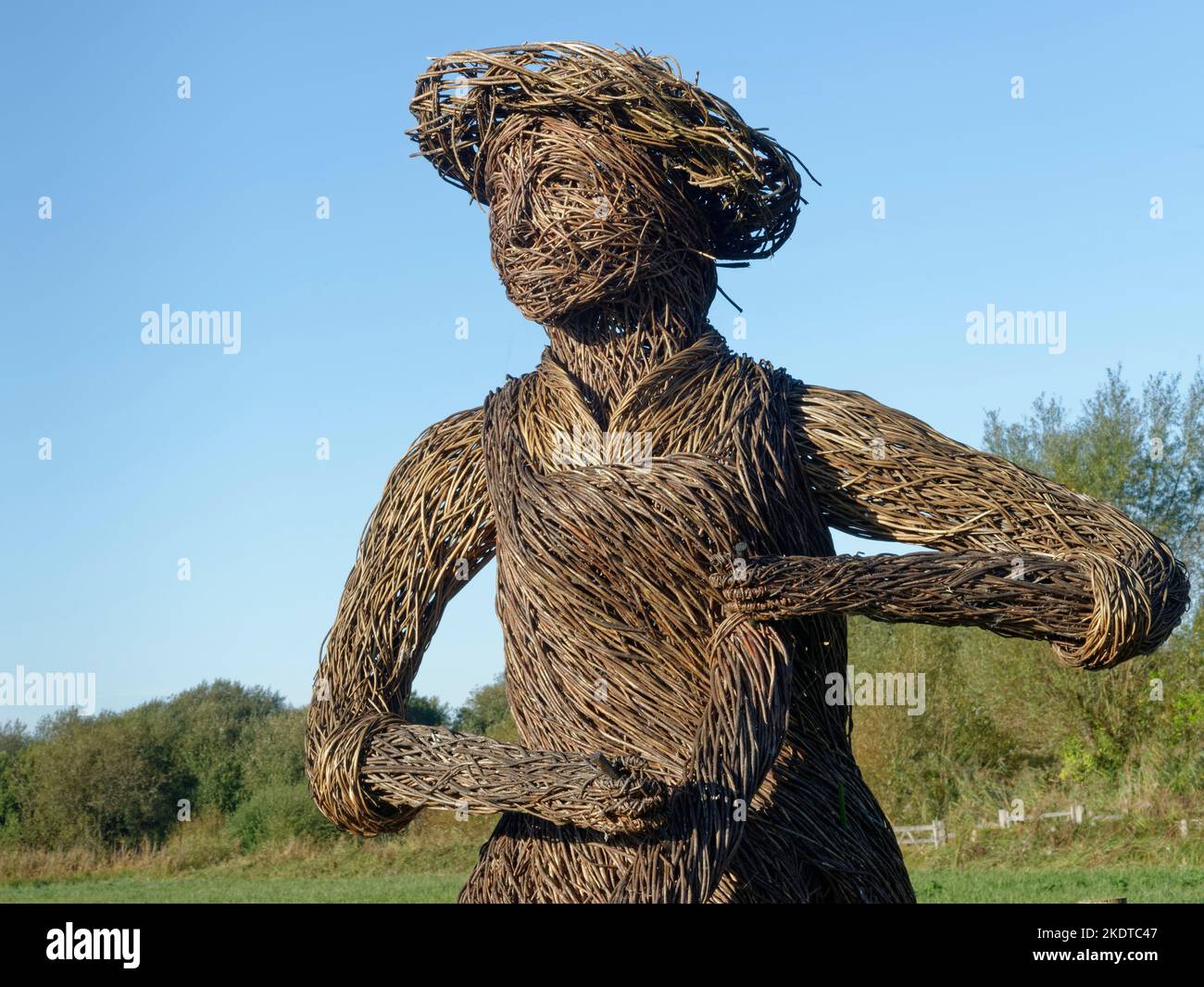 Korbskulptur eines „Brinkers“ mit einer Sense, um Vegetation auf den ...