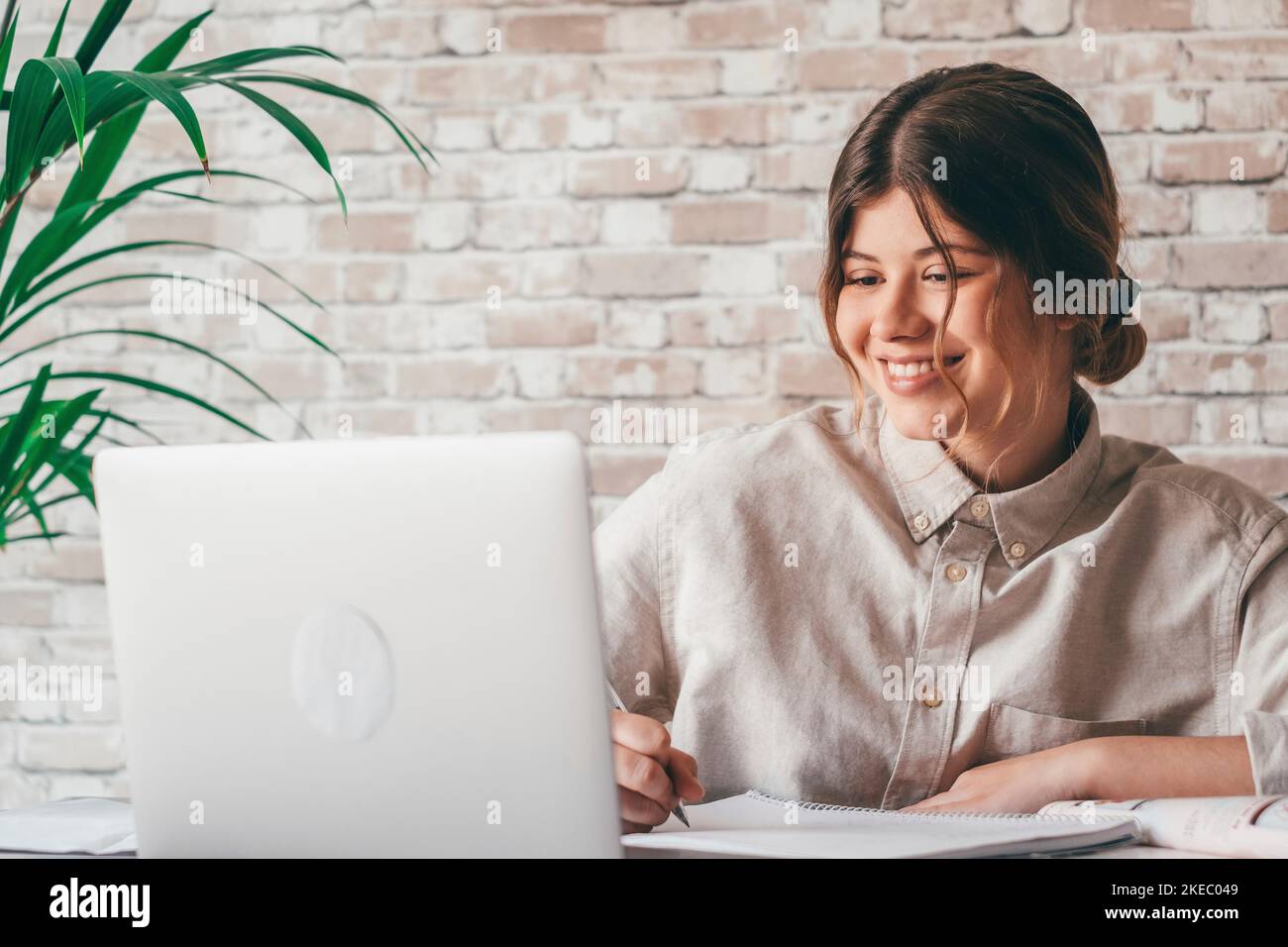 Lächelnde Frau schreiben Notizen sehen Webinar Studie Arbeit auf Laptop ...