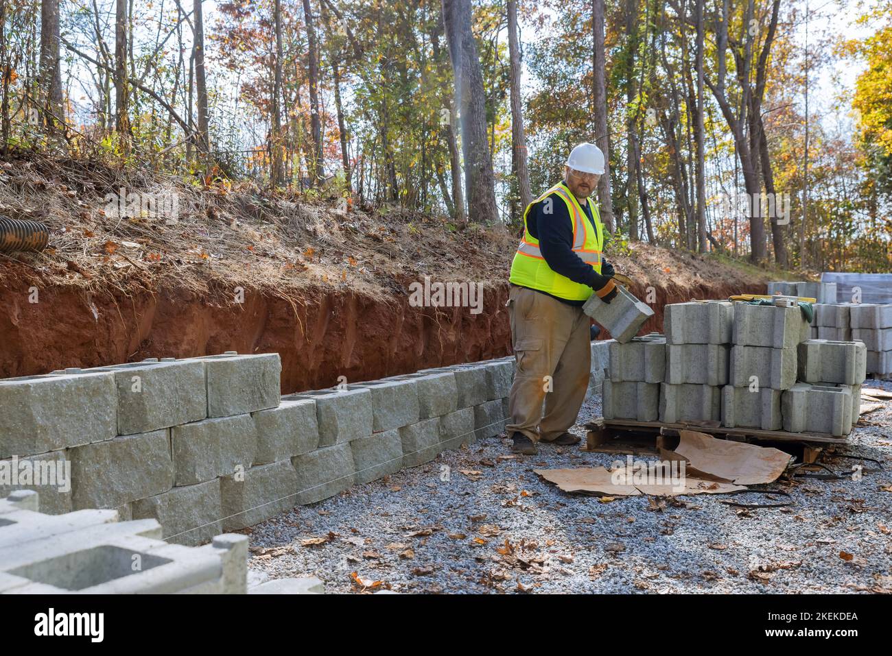 Der Mensch verwendet beim Bau einer Betonblockwand ein ...