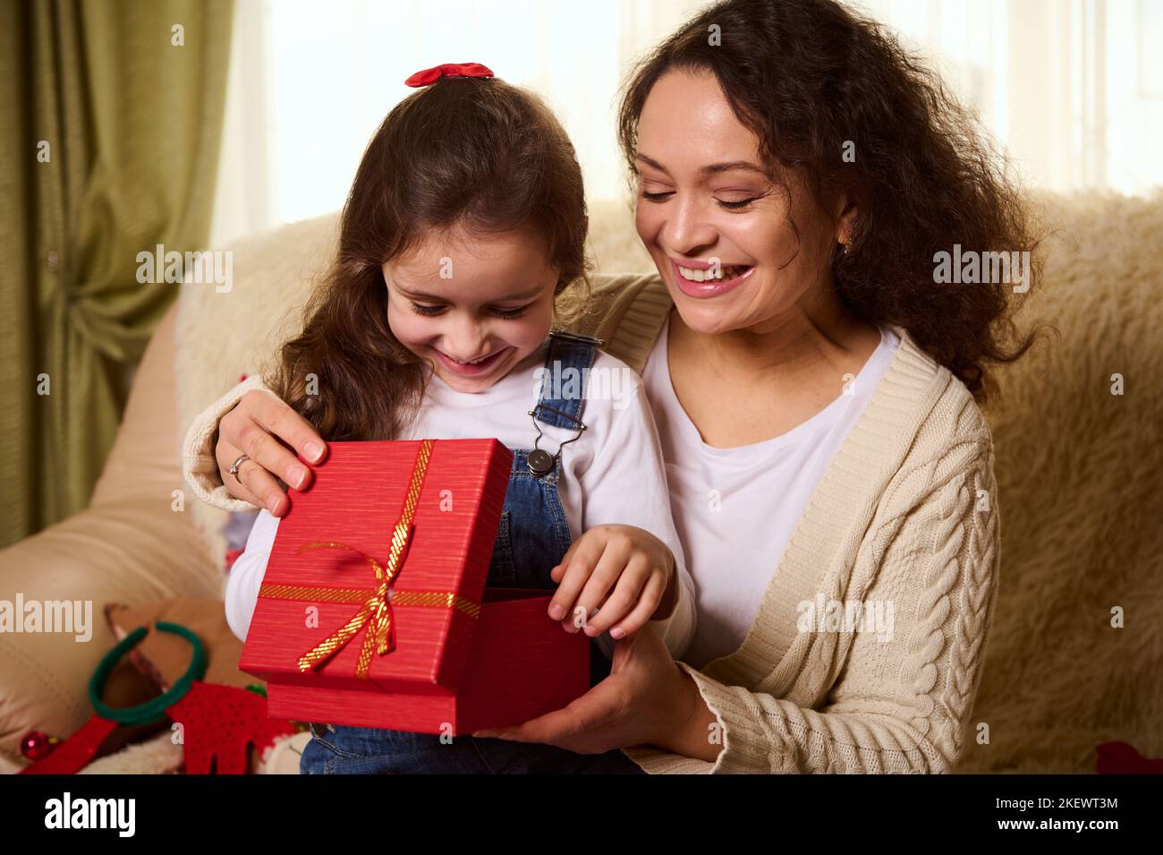 Das kleine Mädchen, die hübsche Tochter, sitzt auf den Knien ihrer ...