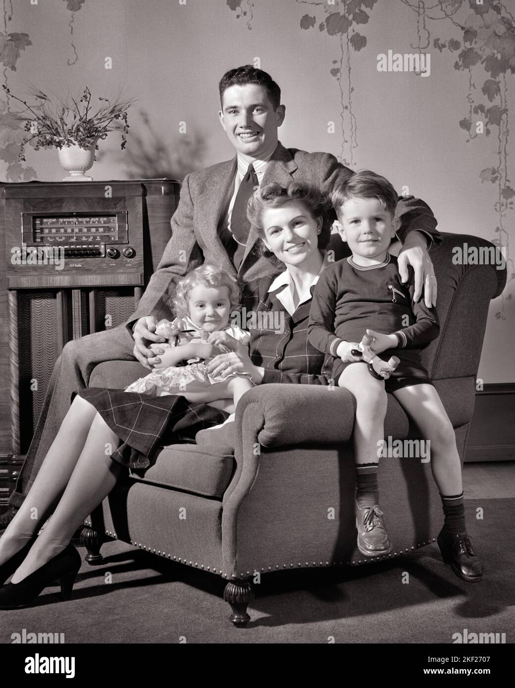 1940S GLÜCKLICH LÄCHELNDE FAMILIE VON VIER SITZEN ZUSAMMEN IM ...