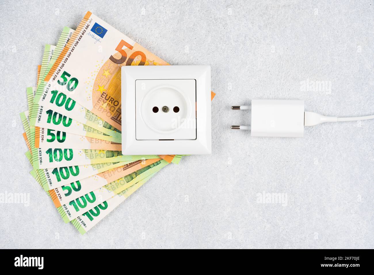 Weiße Steckdose mit Stecker mit vielen Euro-Banknoten auf hellem ...