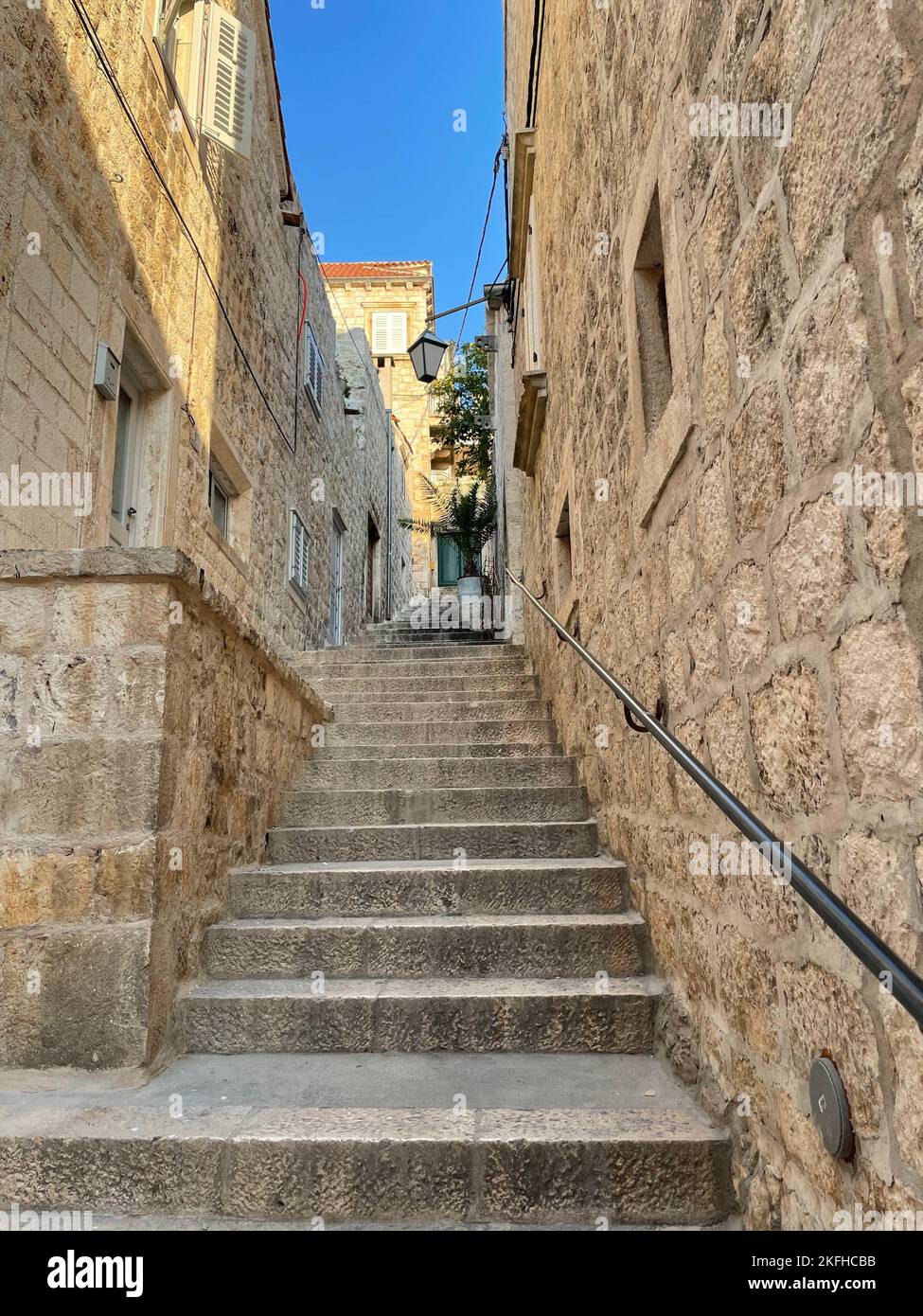 Eine vertikale Aufnahme einer engen Gasse mit Steinmauern und Treppen ...