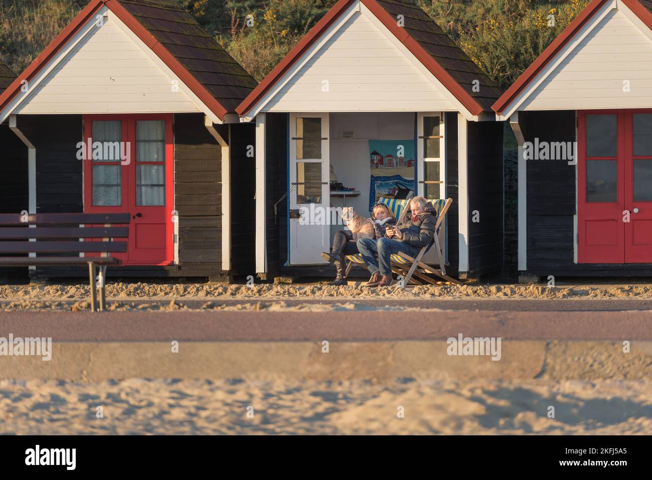 Touristen saßen auf Liegestühlen in ihrer Strandhütte an der Promenade ...
