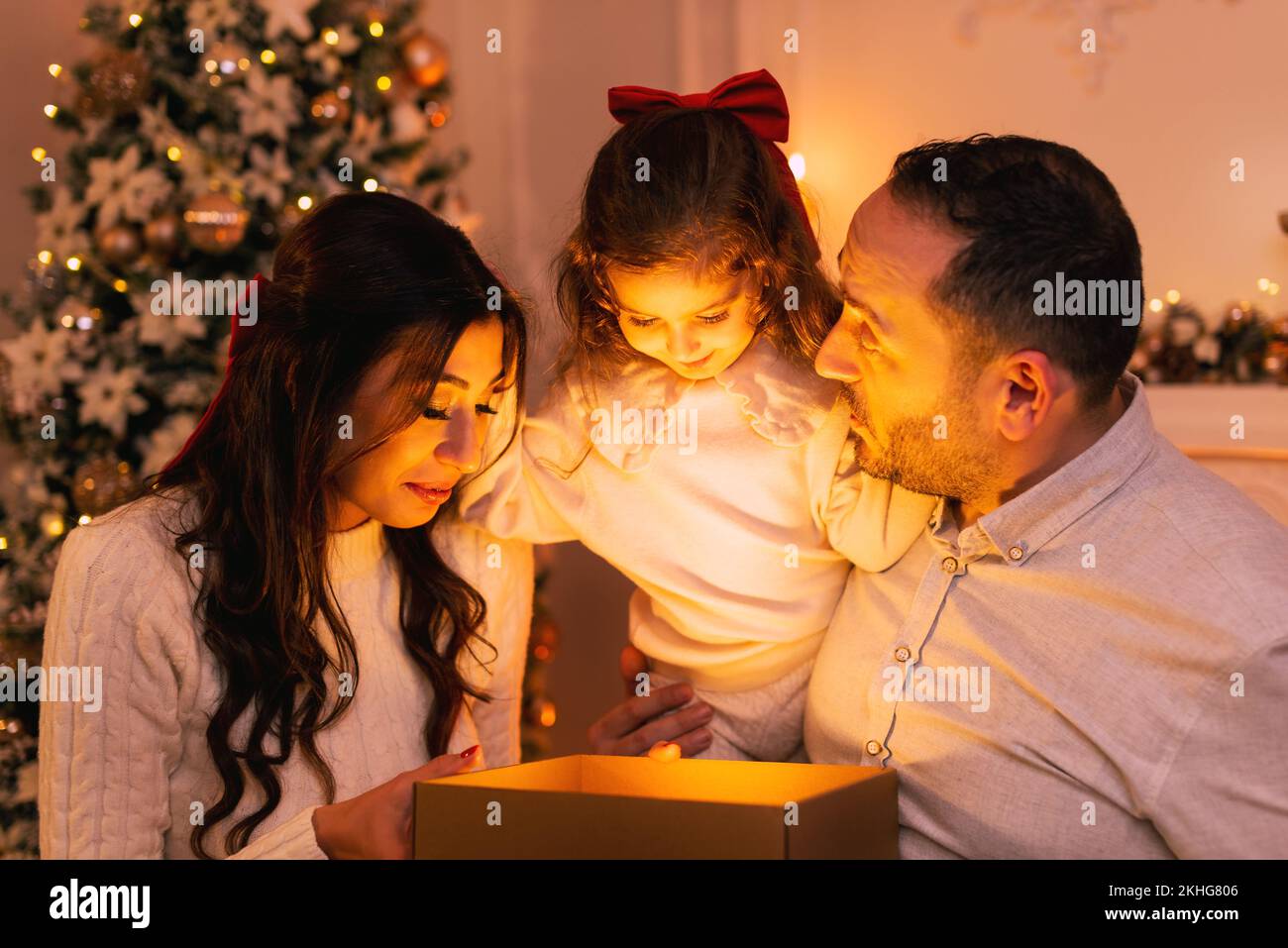 Glückliche Familie mit überraschenden Emotionen beim Öffnen einer ... Glückliche Familie mit überraschenden Emotionen beim Öffnen einer ...