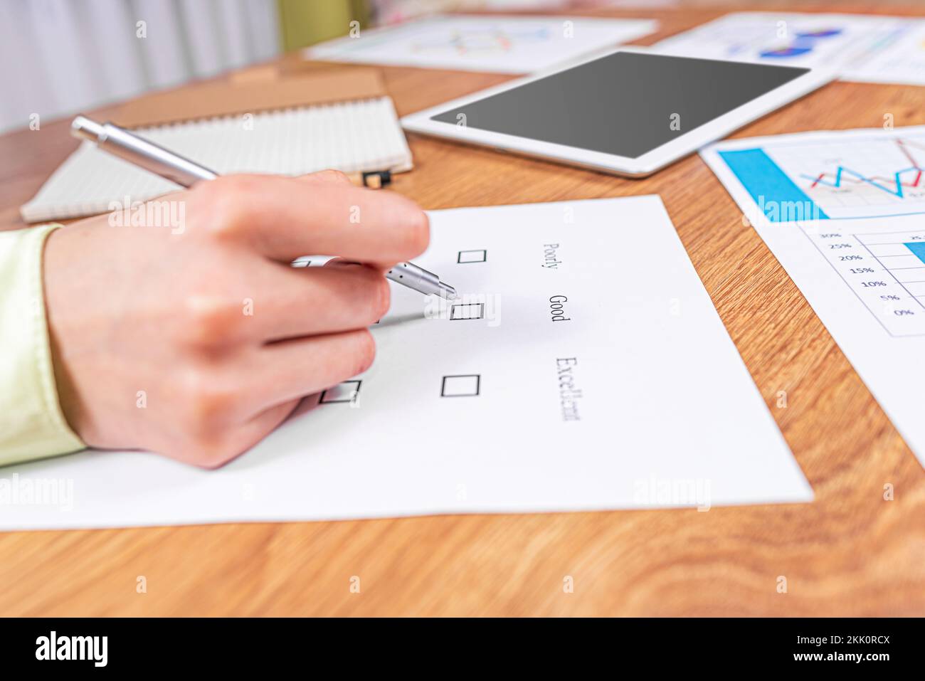 Die Hand einer Frau füllt eine Checkliste oder einen Test aus, der ein ...