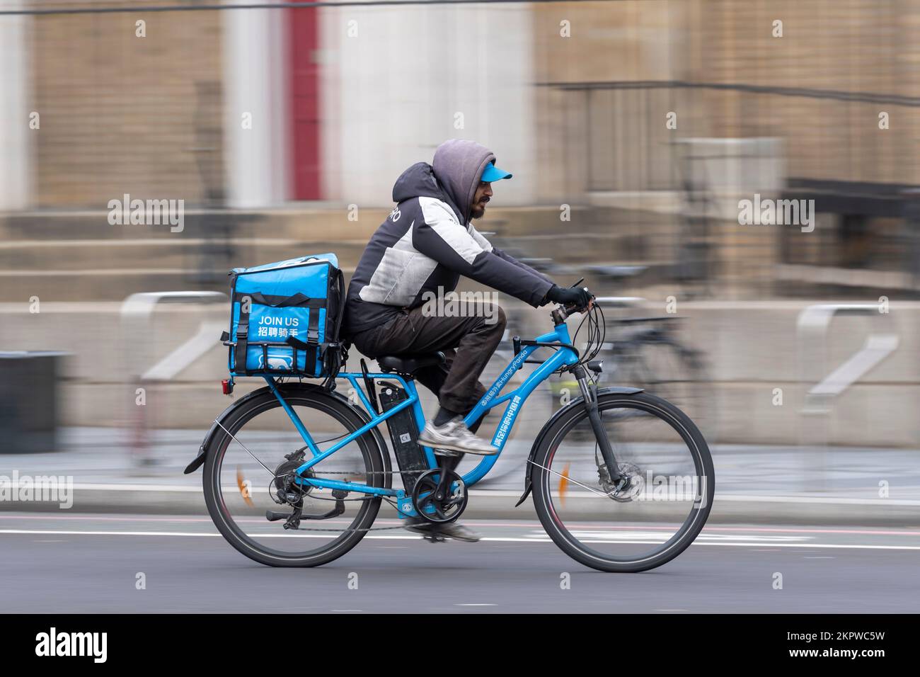 Ein hungriger Panda-Fahrradkurier, der auf einem E-Bike entlang der Waterloo Road fährt. Die ...
