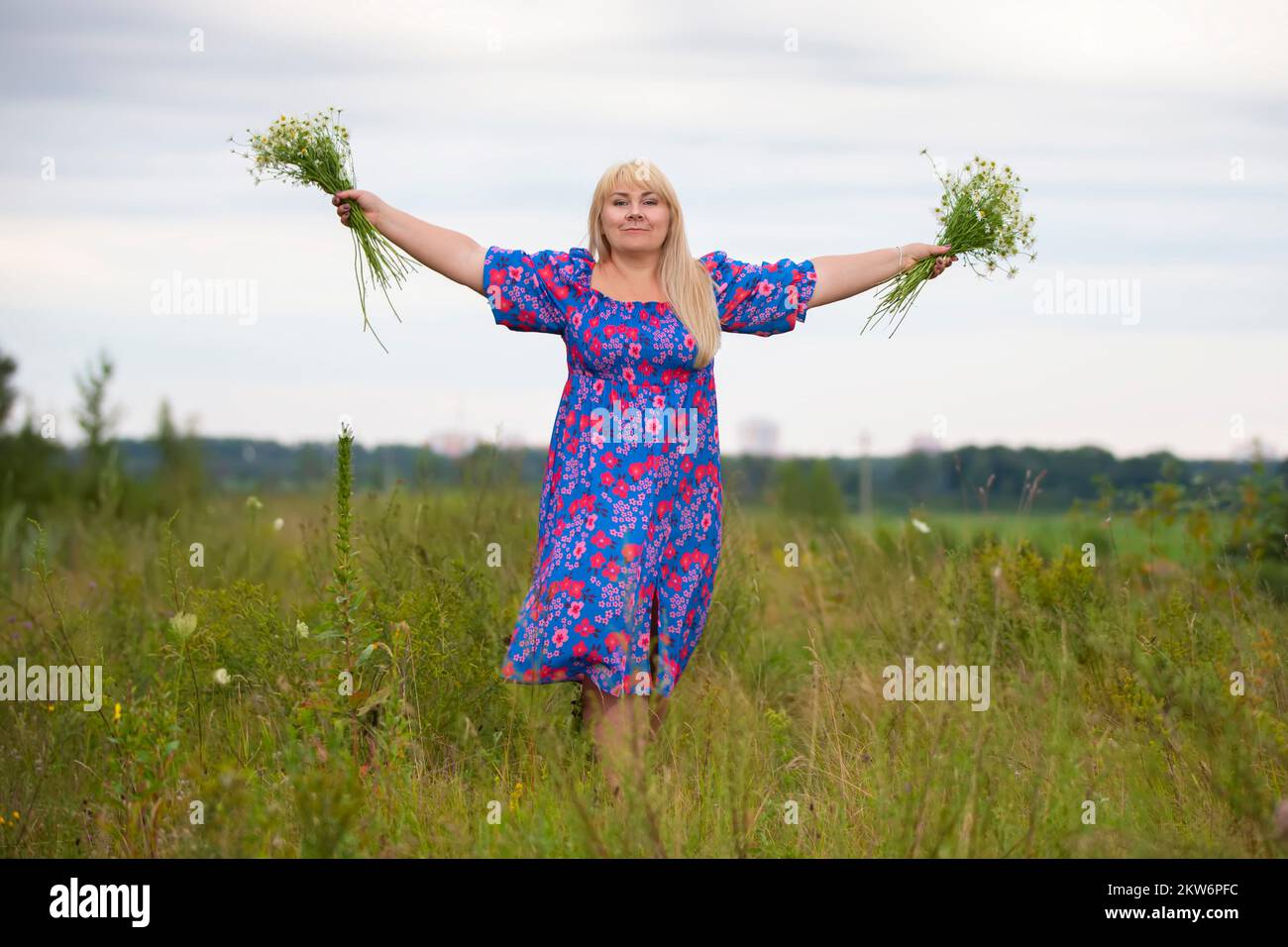Schöne plus size Frau mit weißen Haaren in einem Sommerkleid posiert im ...