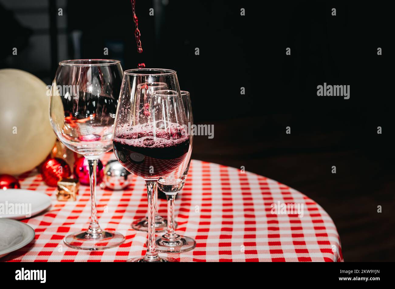 Bei der Weihnachtsfeier schütten Sie Rotwein in Gläser, halten die ...
