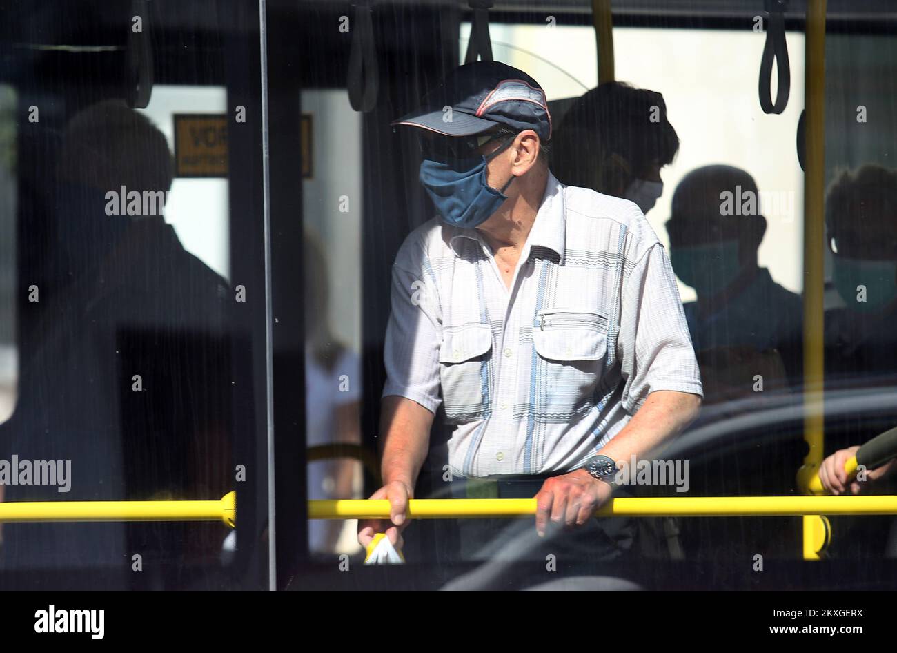 Menschen tragen medizinische Masken, da sie öffentliche Verkehrsmittel ...