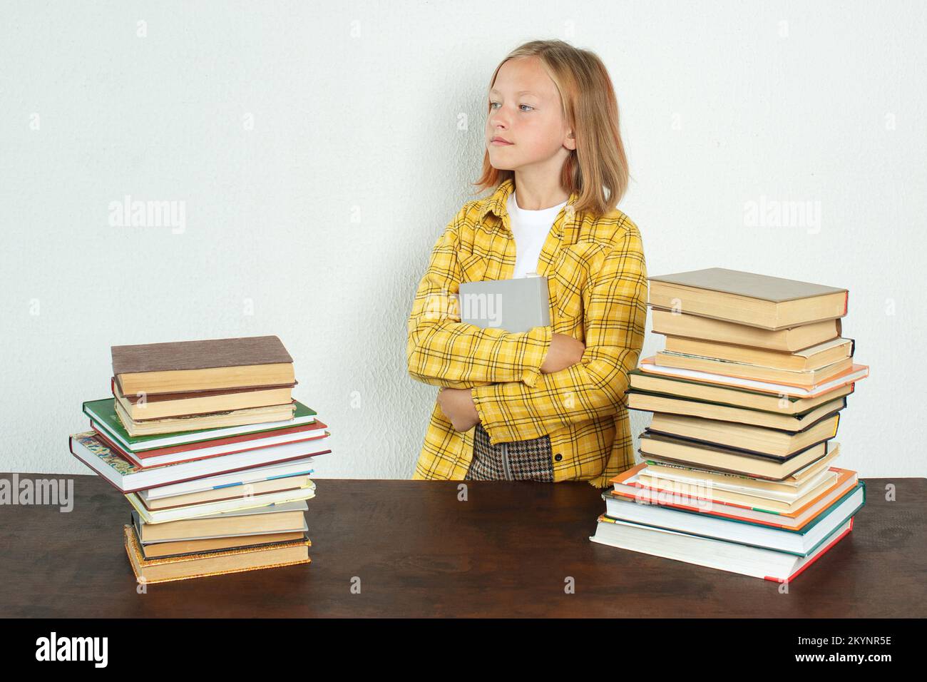Bildungskonzept. Ein Teenager steht neben einem Tisch mit Büchern und ...